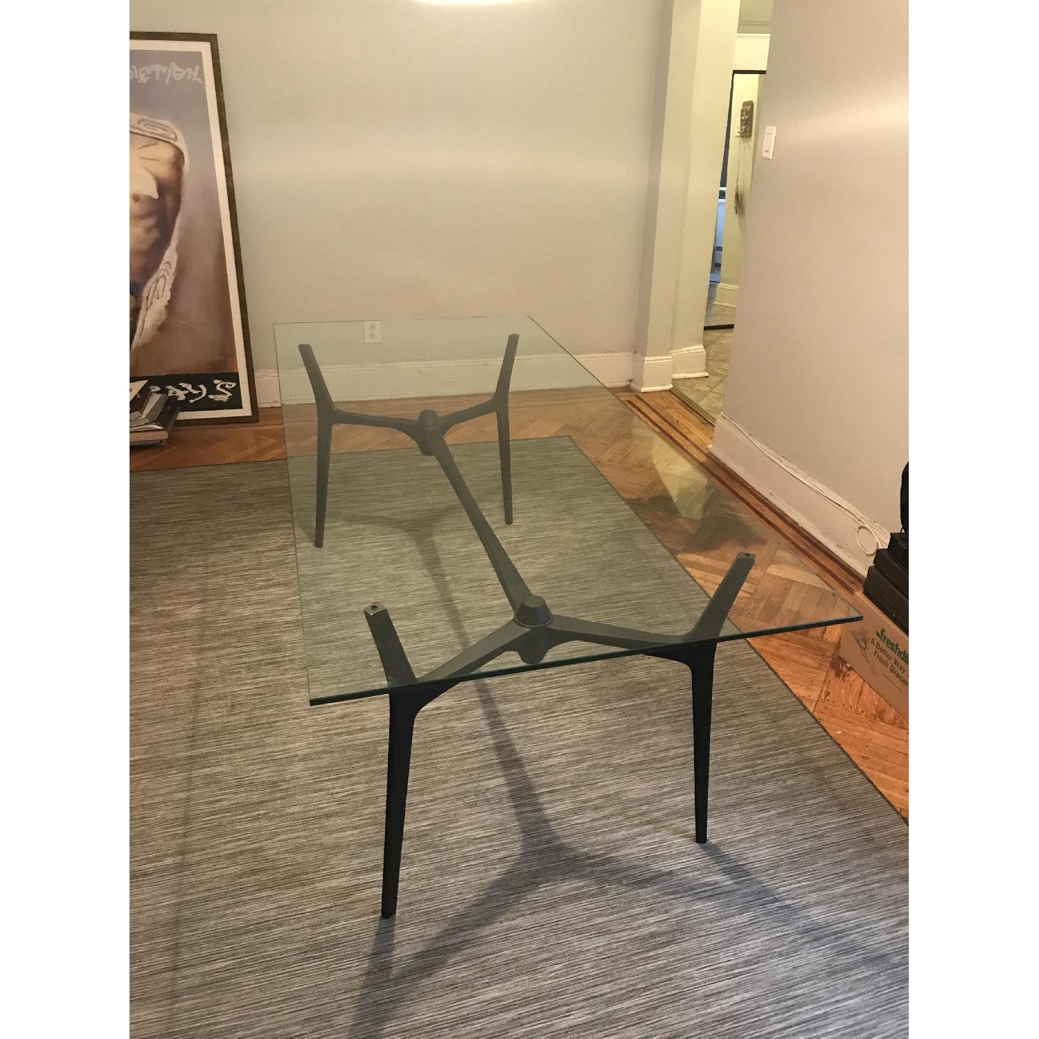 CB2 Glass Dining Table w/ Black Metal Base - AptDeco