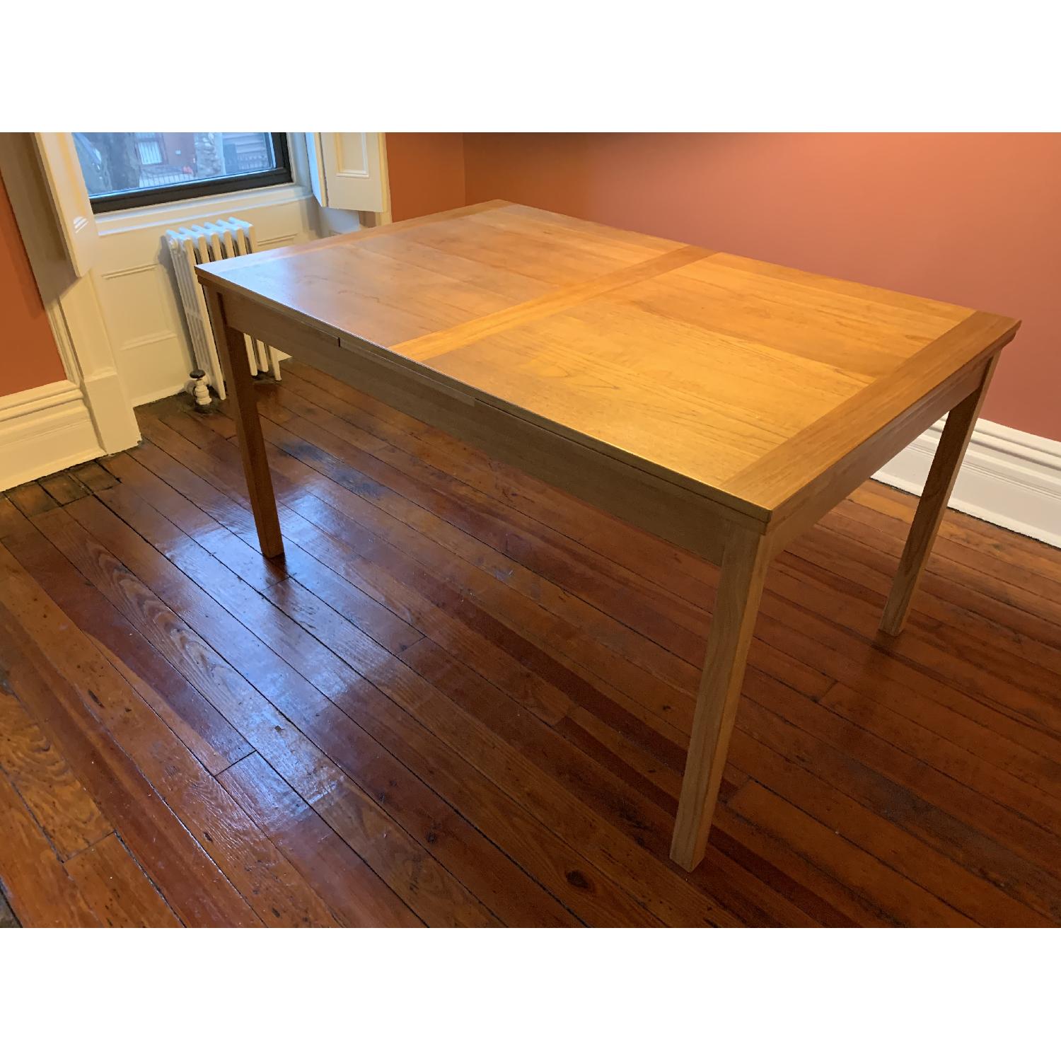 Solid oak dining table with sliding extender leaves - AptDeco