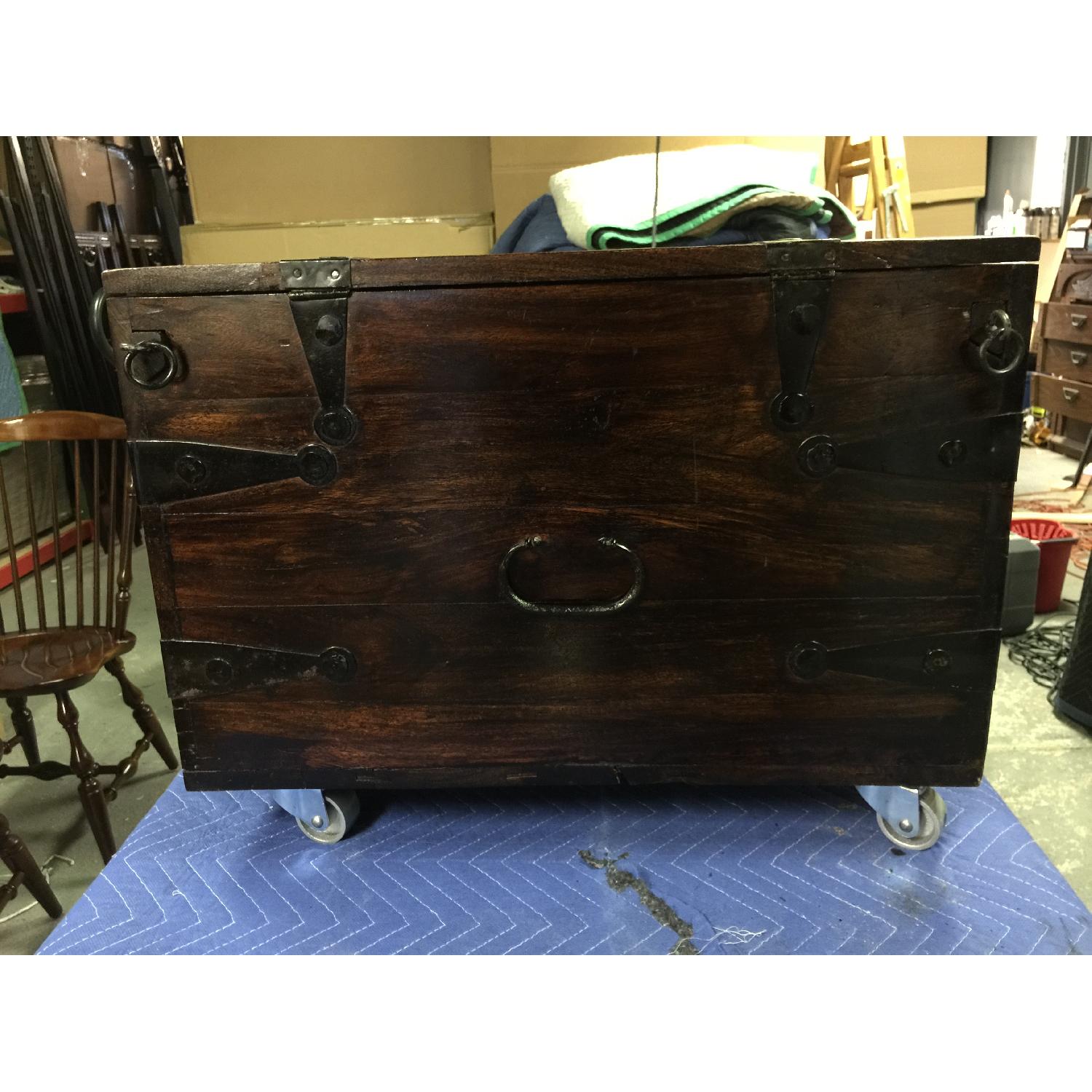 Vintage Wooden Chest with Metal Wheels - AptDeco